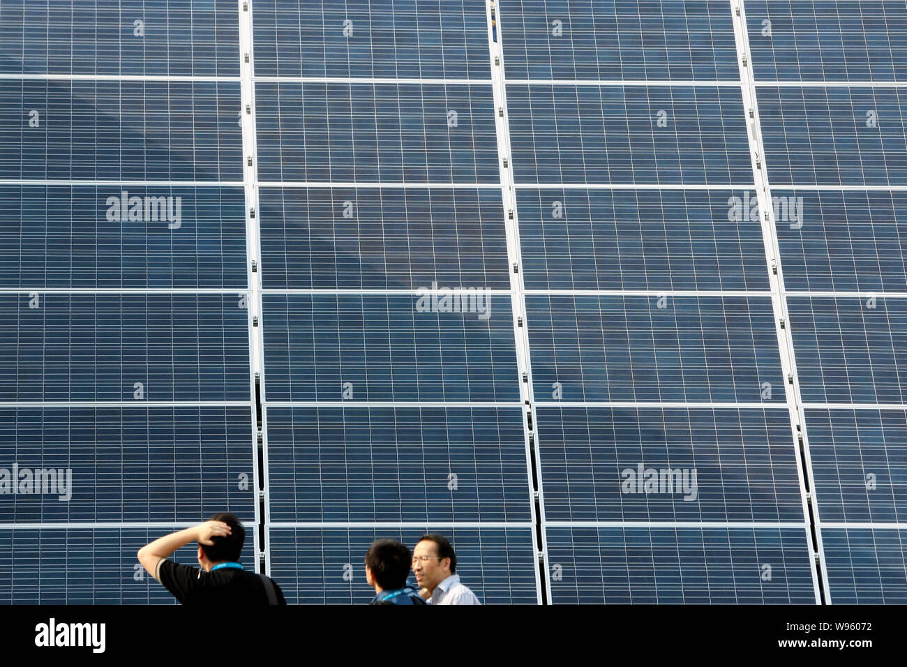 Visitors walk past an array of solar panels during the SNEC 6th (2012 ...