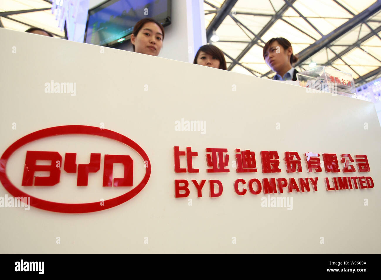--FILE--Chinese staff members pose at the stand of BYD during the SNEC 6th (2012) International ...