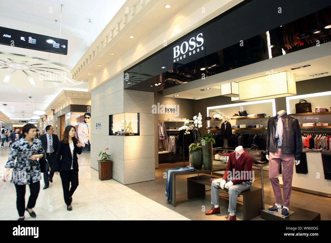--FILE--Chinese shoppers walk past the Hugo Boss boutique at the No.1 ...