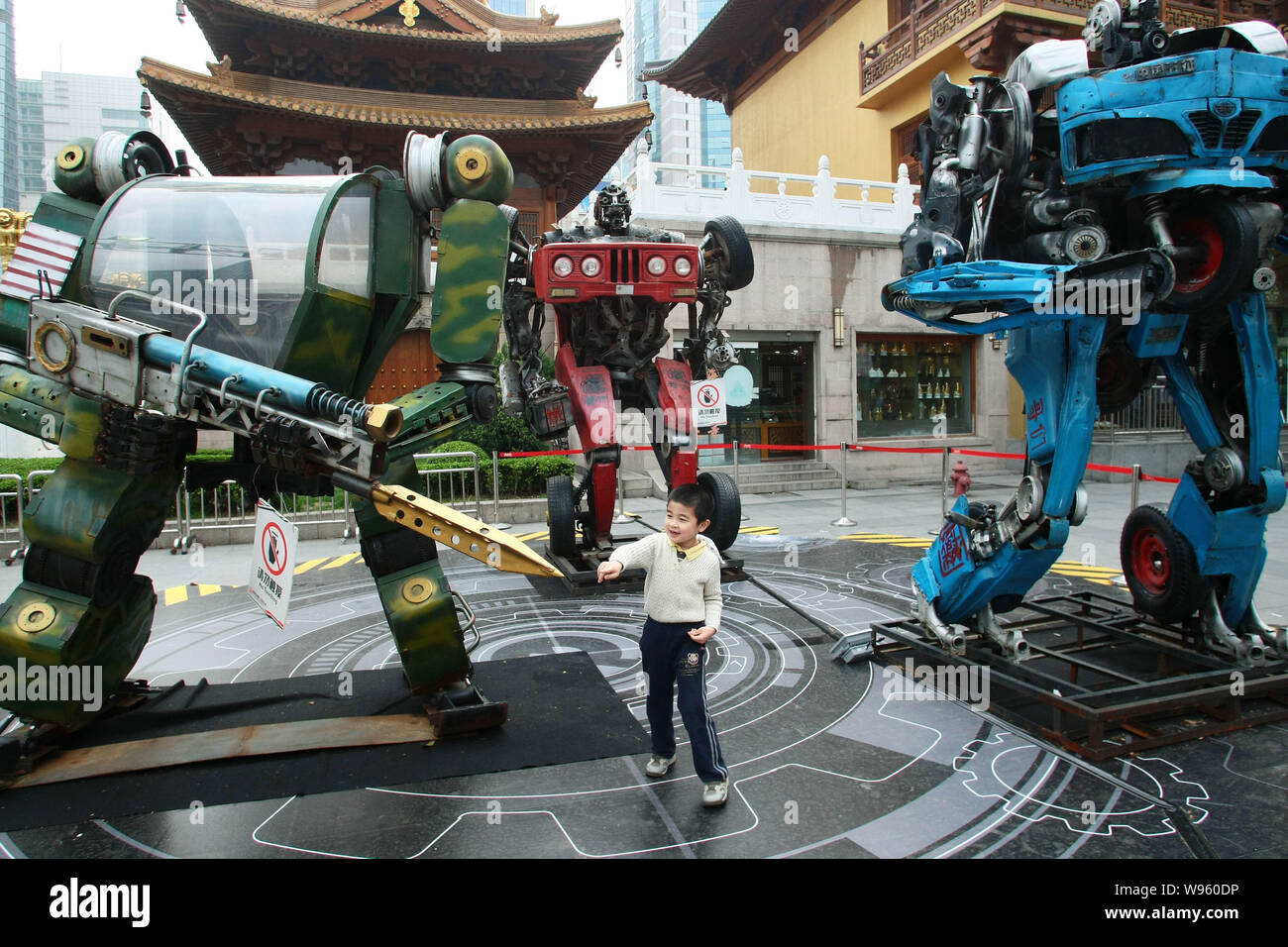A kid poses by transformers which are made of recycled iron and steel ...