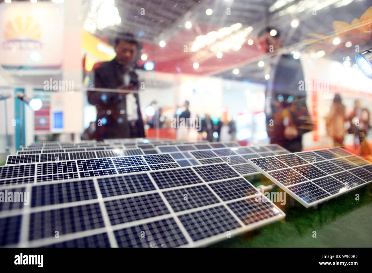 Visitors look at models of solar panels during the 7th AsiaSolar ...