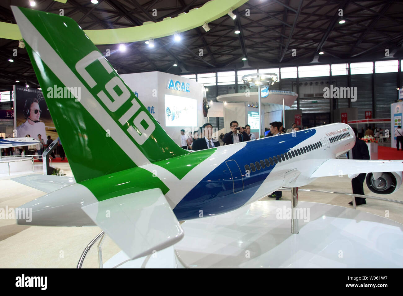 Visitors look at a model plane of C919 at the stand of COMAC ...