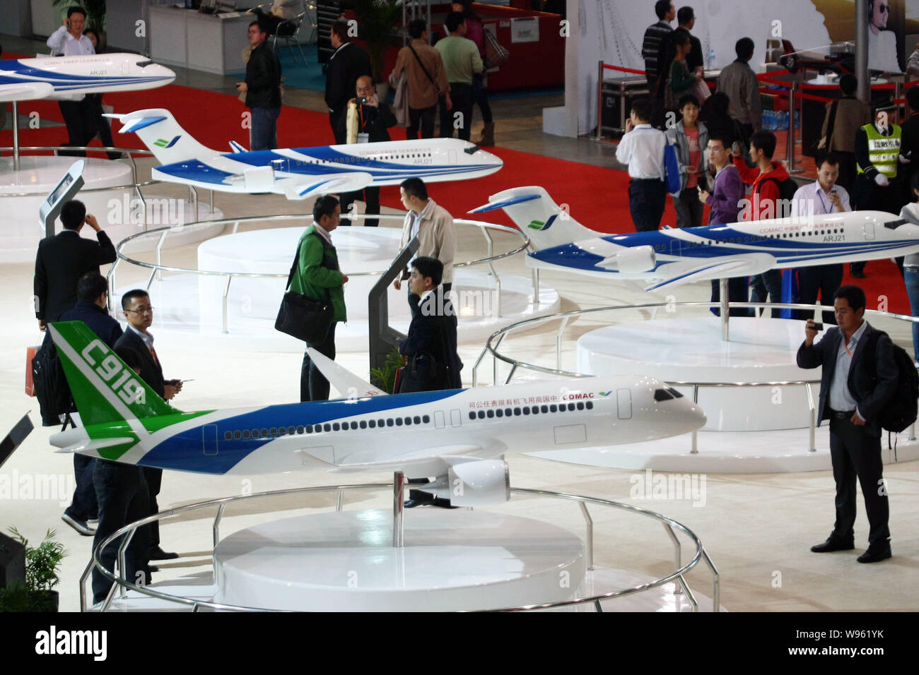Visitors look at model planes of C919 and ARJ21 at the stand of COMAC ...