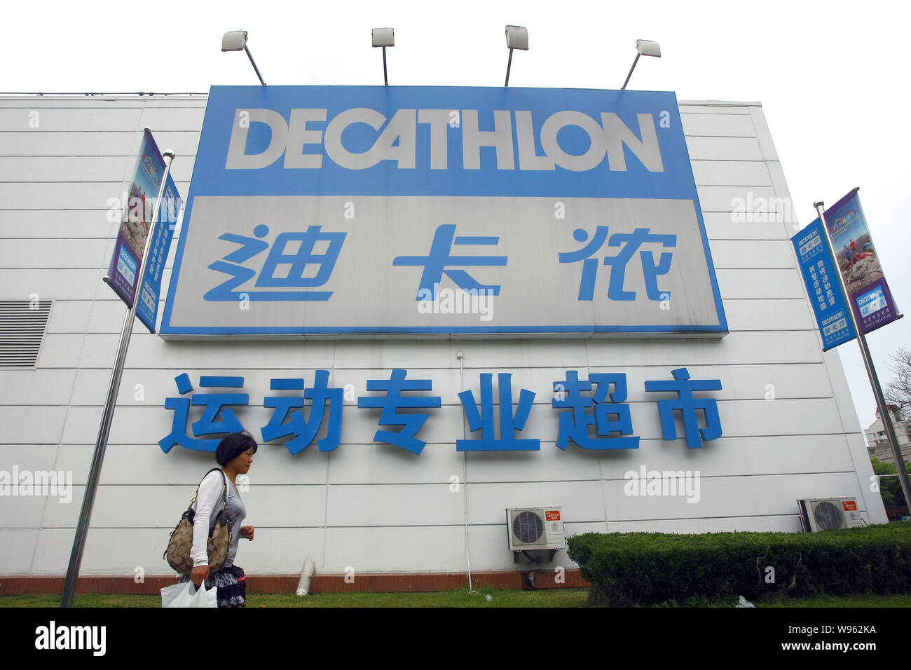 --File--A Chinese woman walks past a Decathlon store in Shanghai, China ...