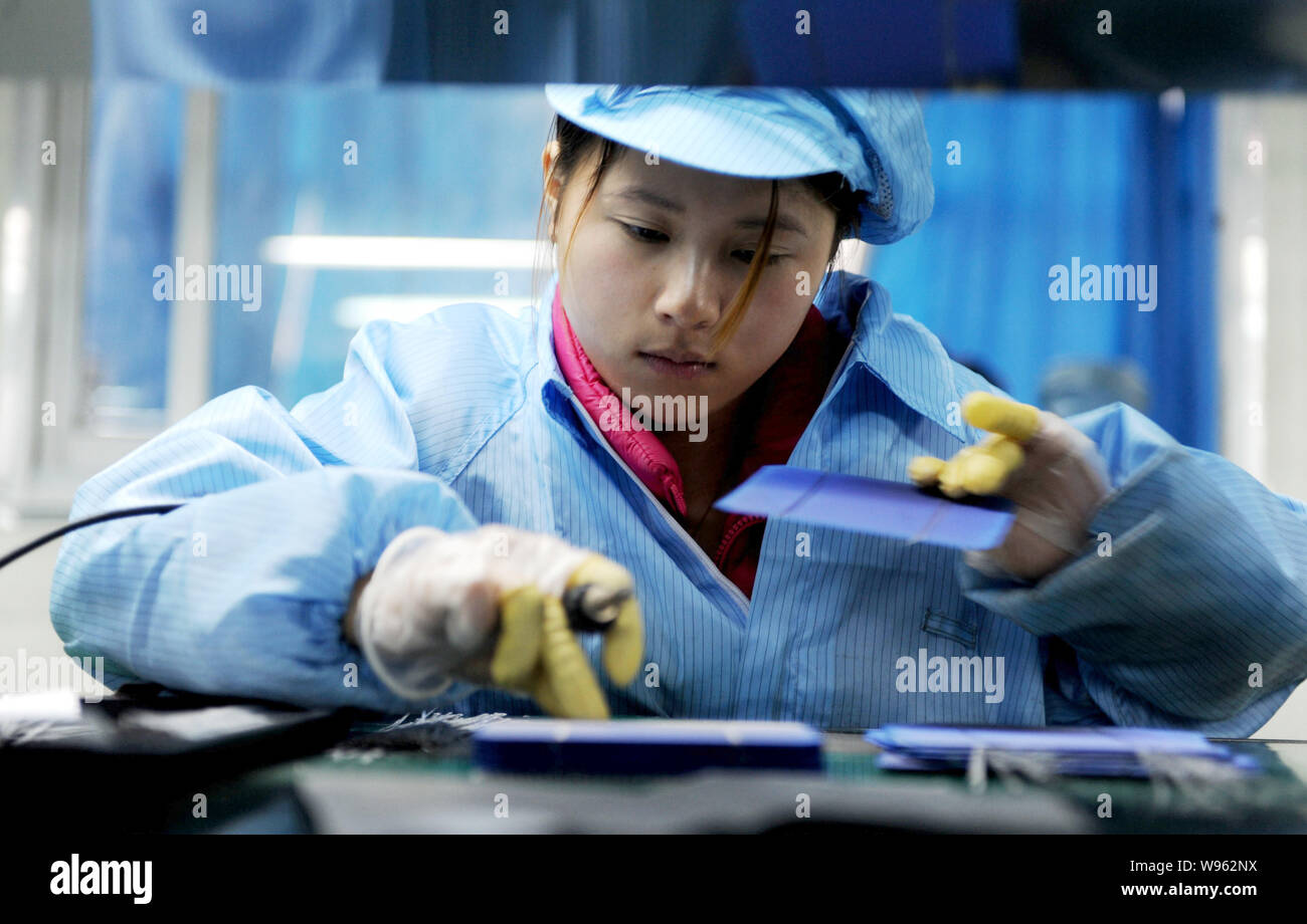 --FILE--A female Chinese worker manufactures photovoltaic (PV) cells to ...