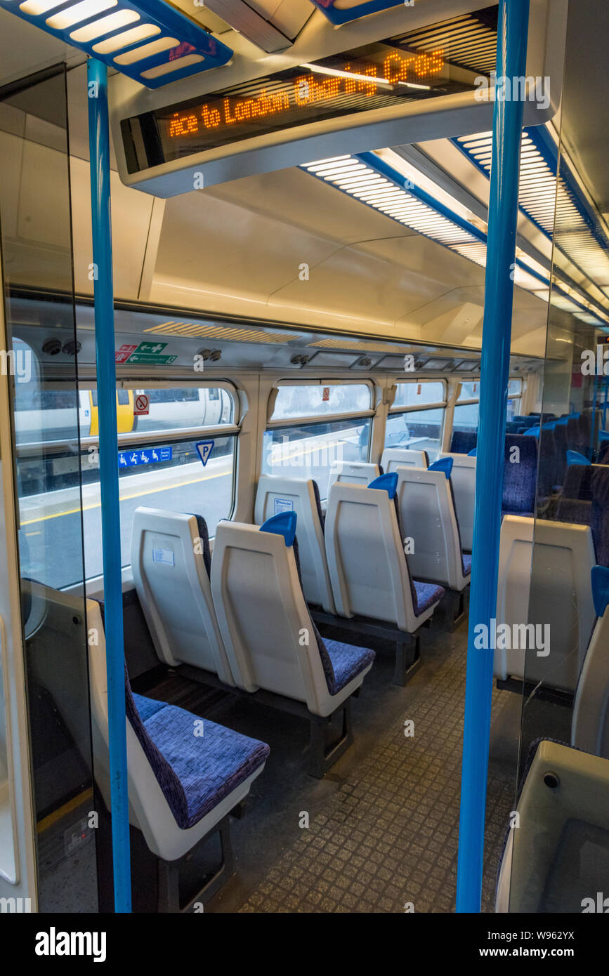 the inside or interior of a modern railway carriage with empty seats ...