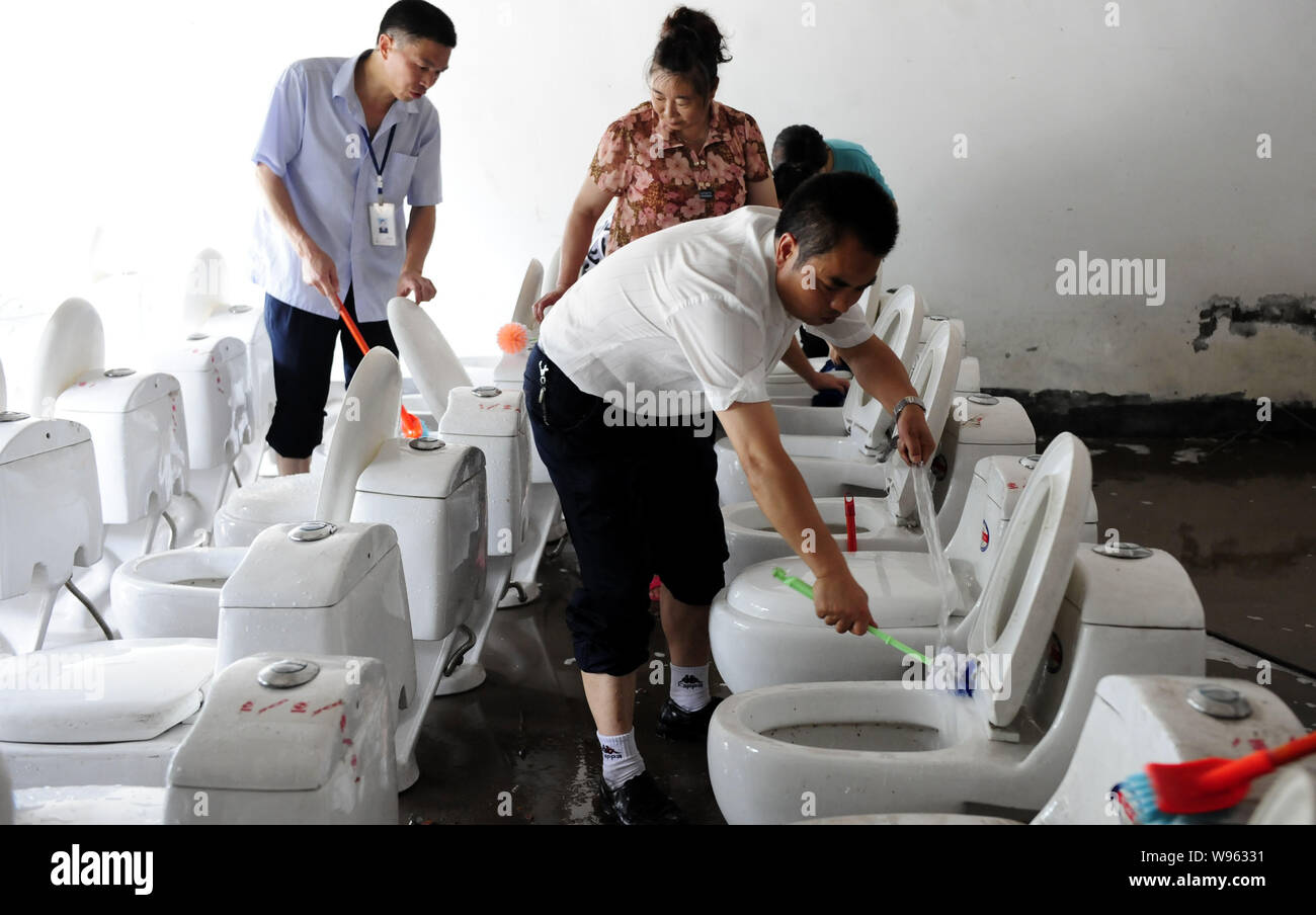 Chinese staff members are cleaning discarded flush toilets at a ...