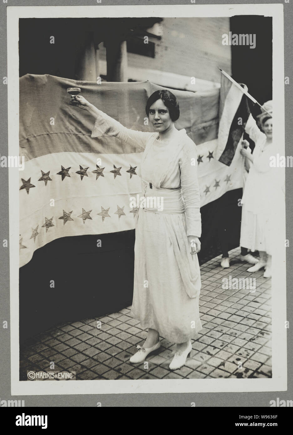 Alice Paul, full-length portrait, standing, facing left, raising glass ...