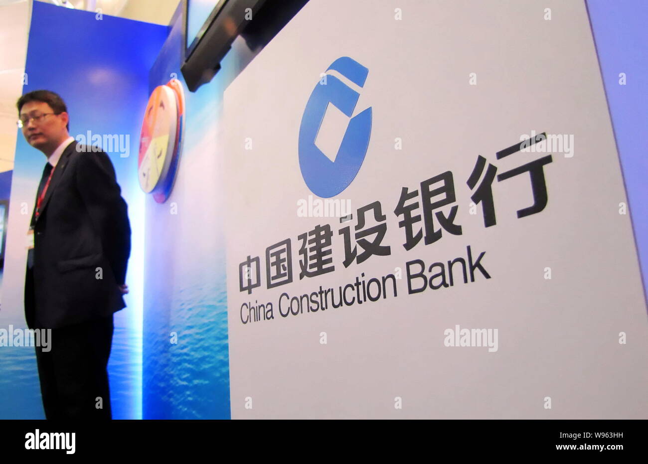 --File--An employee poses at the stand of China Construction Bank (CCB ...
