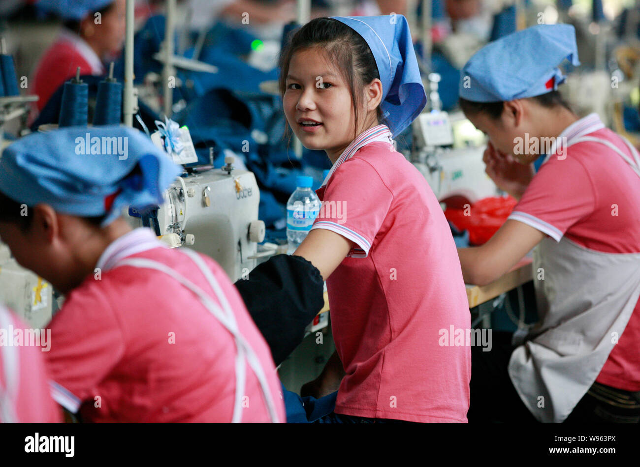 --FILE--Female Chinese workers sew clothes to be exported to southeast Asia at a garment factory ...
