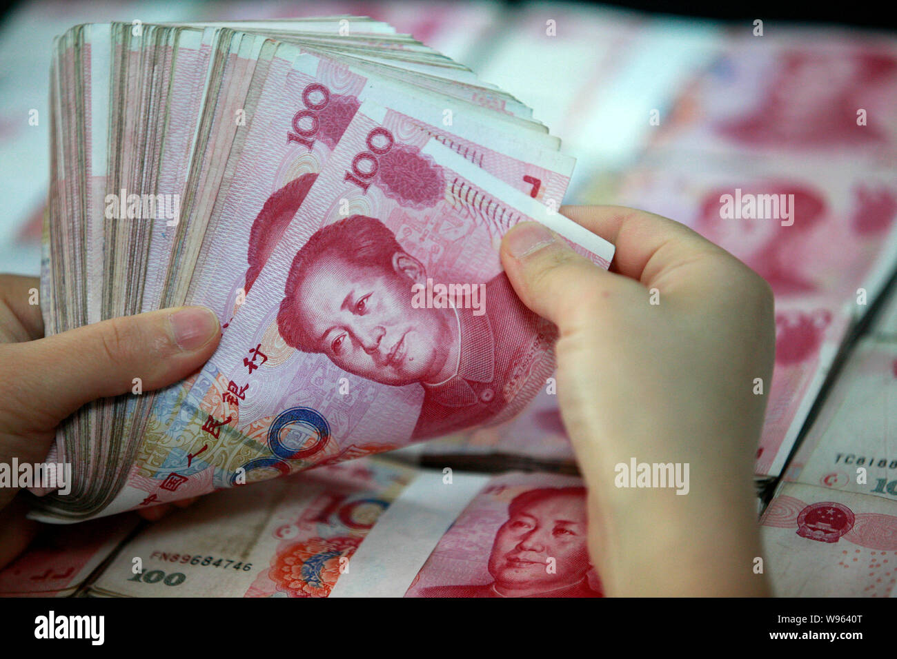 --FILE--A Chinese clerk counts RMB (renminbi) yuan bills at a bank in Huaibei city, east Chinas ...