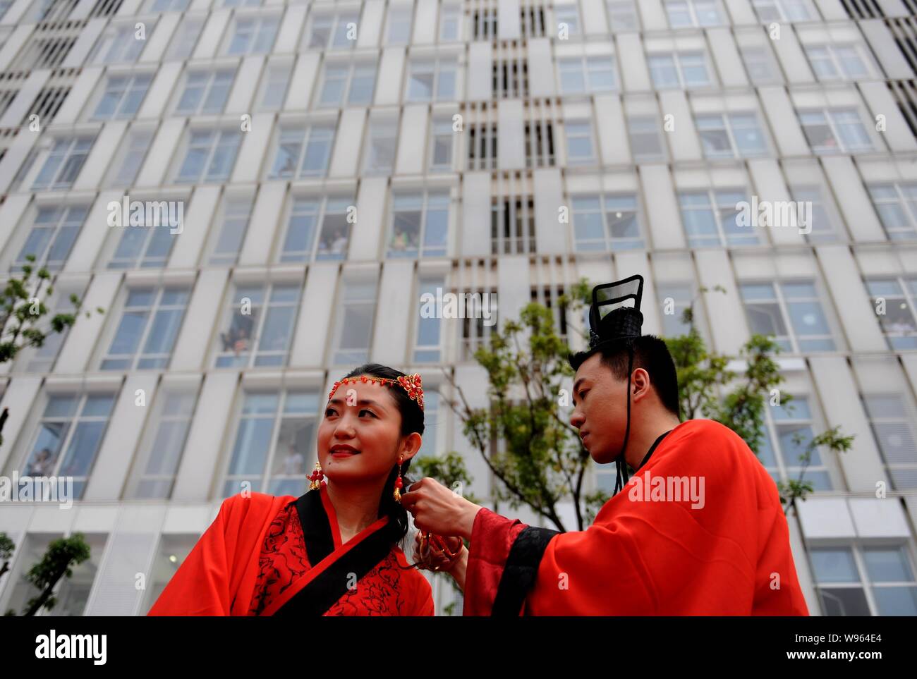 A couple of newlyweds dressed in traditional Han costumes make a ...