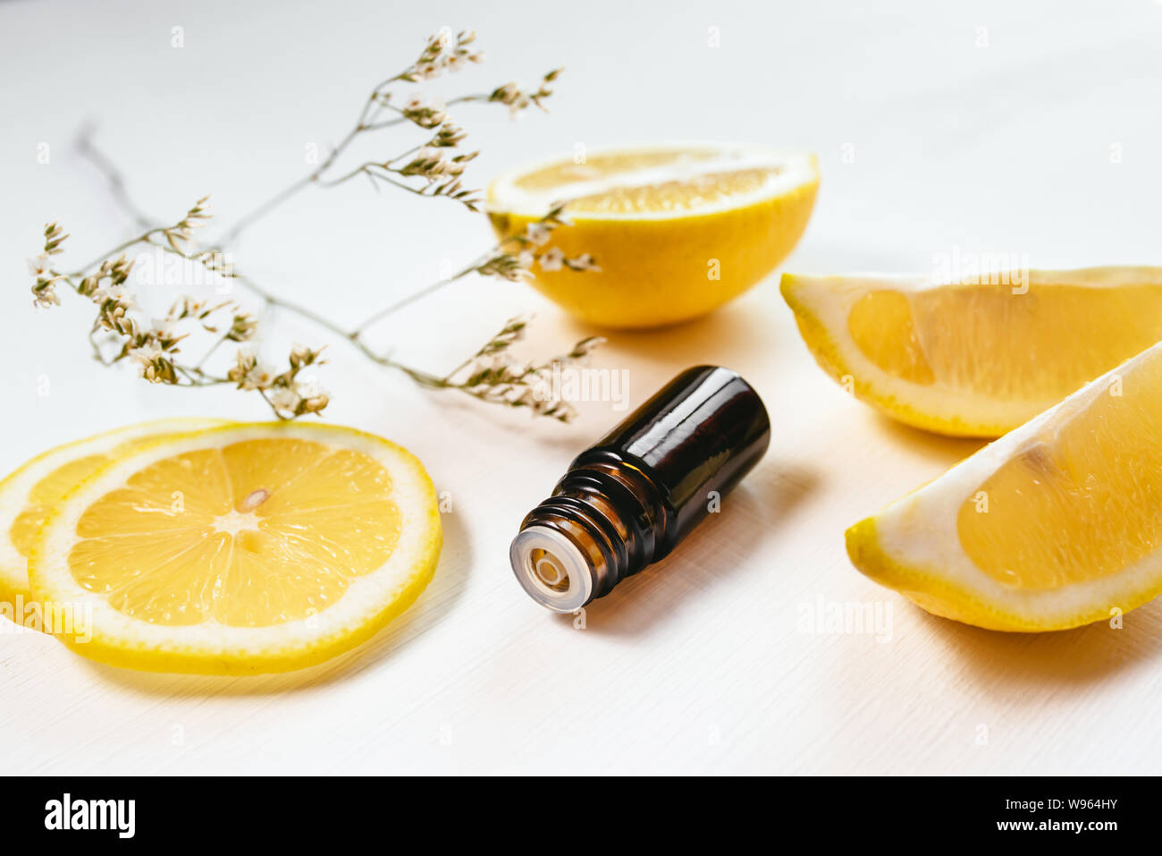 Bottle of lemon essential oil on white background Stock Photo - Alamy