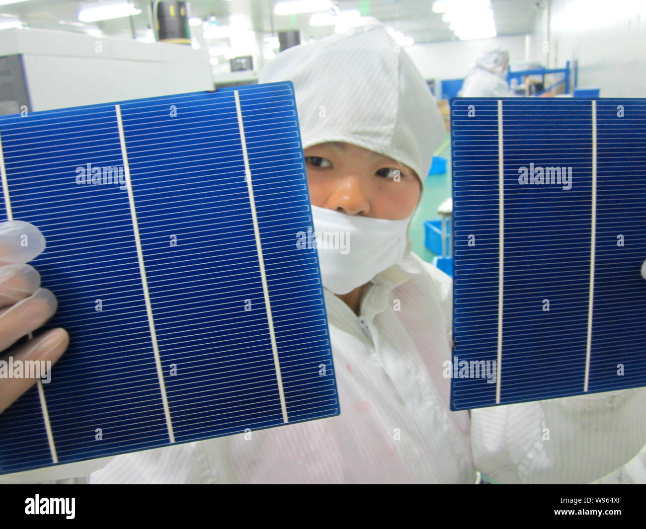 --FILE--A Chinese worker shows photovoltaic (PV) cells of solar panels ...