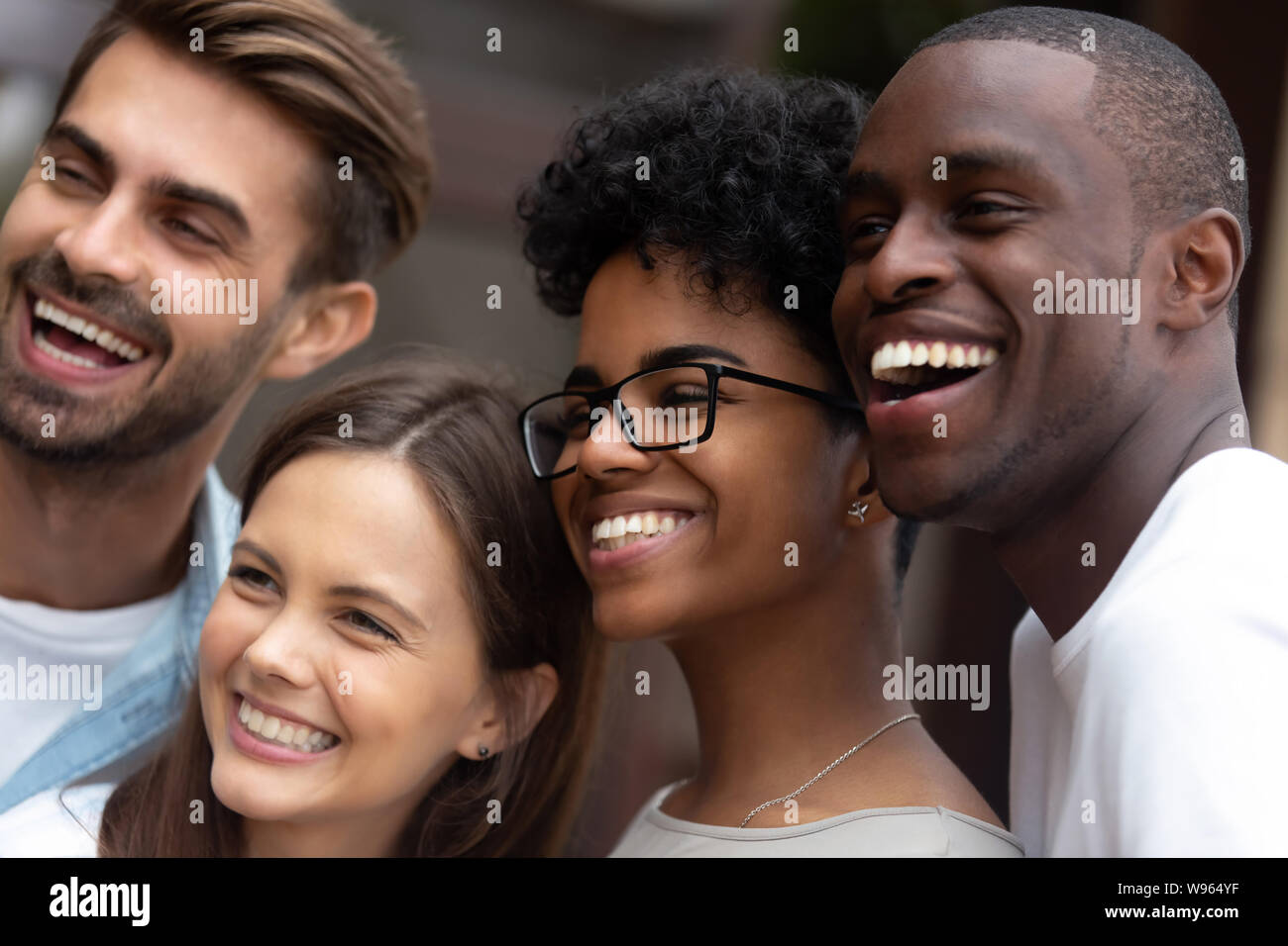 Smiling multiracial millennial friends posing for picture together ...