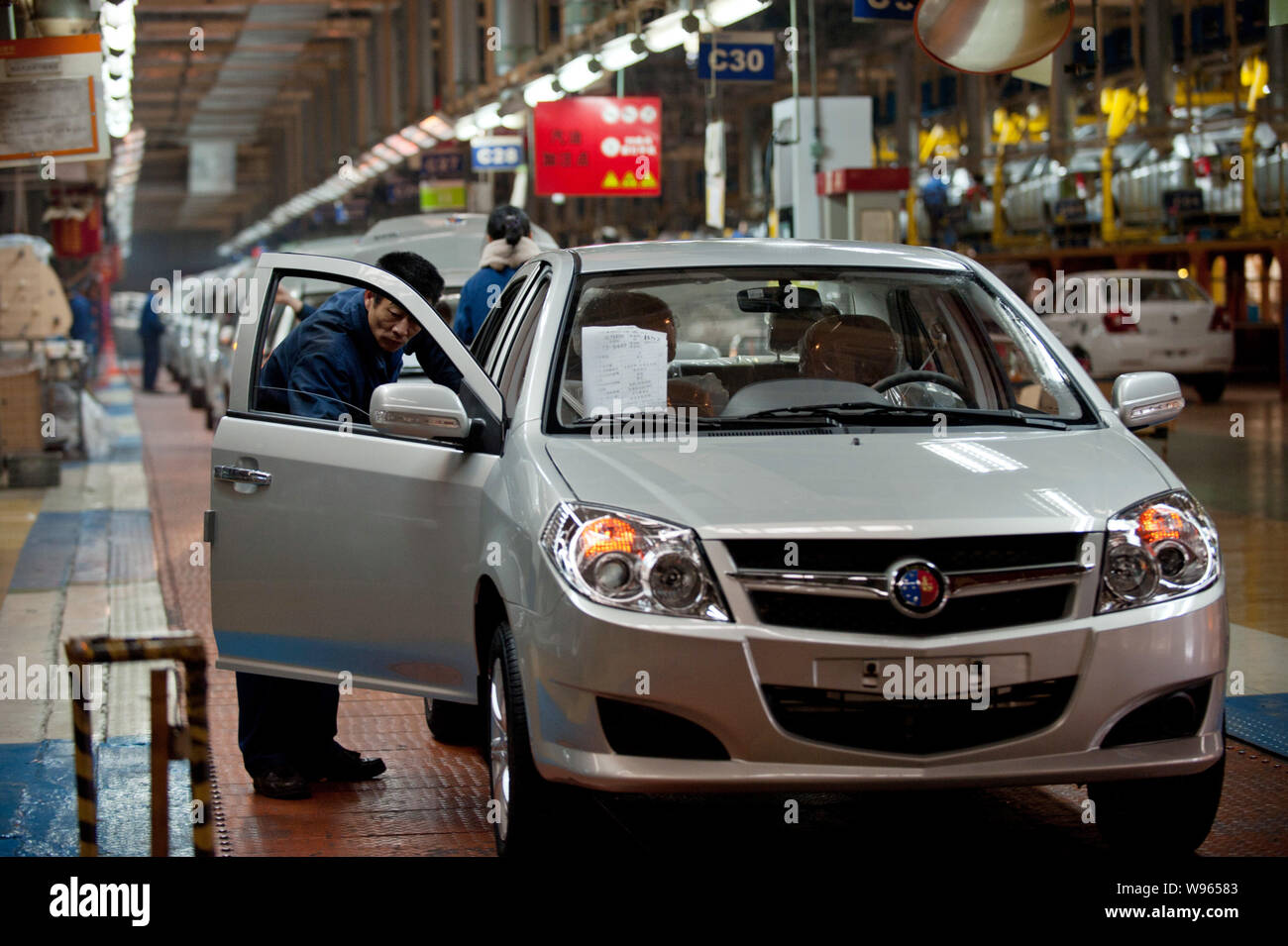--FILE--Chinese factory workers check Englon cars on the assembly line ...