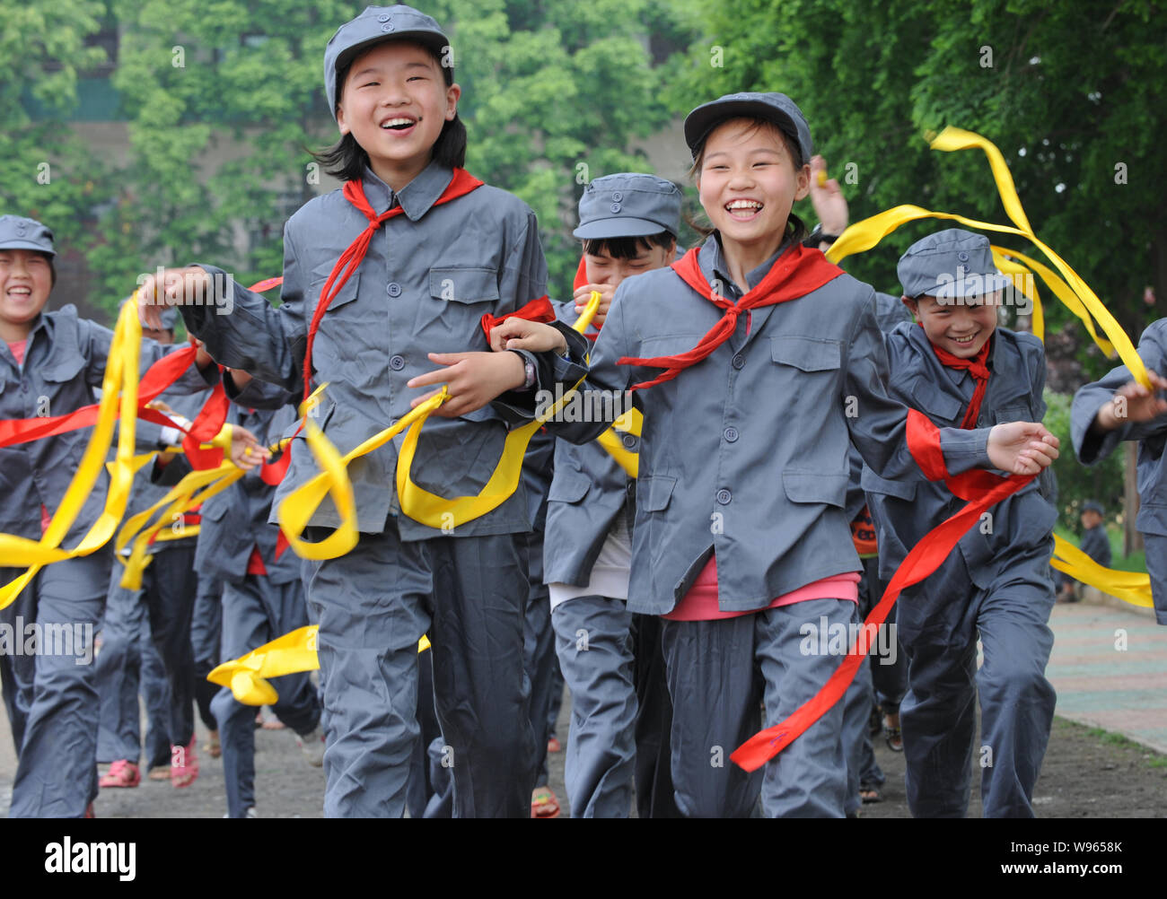 Students wearing uniforms of the Chinese Red Army smile during class ...