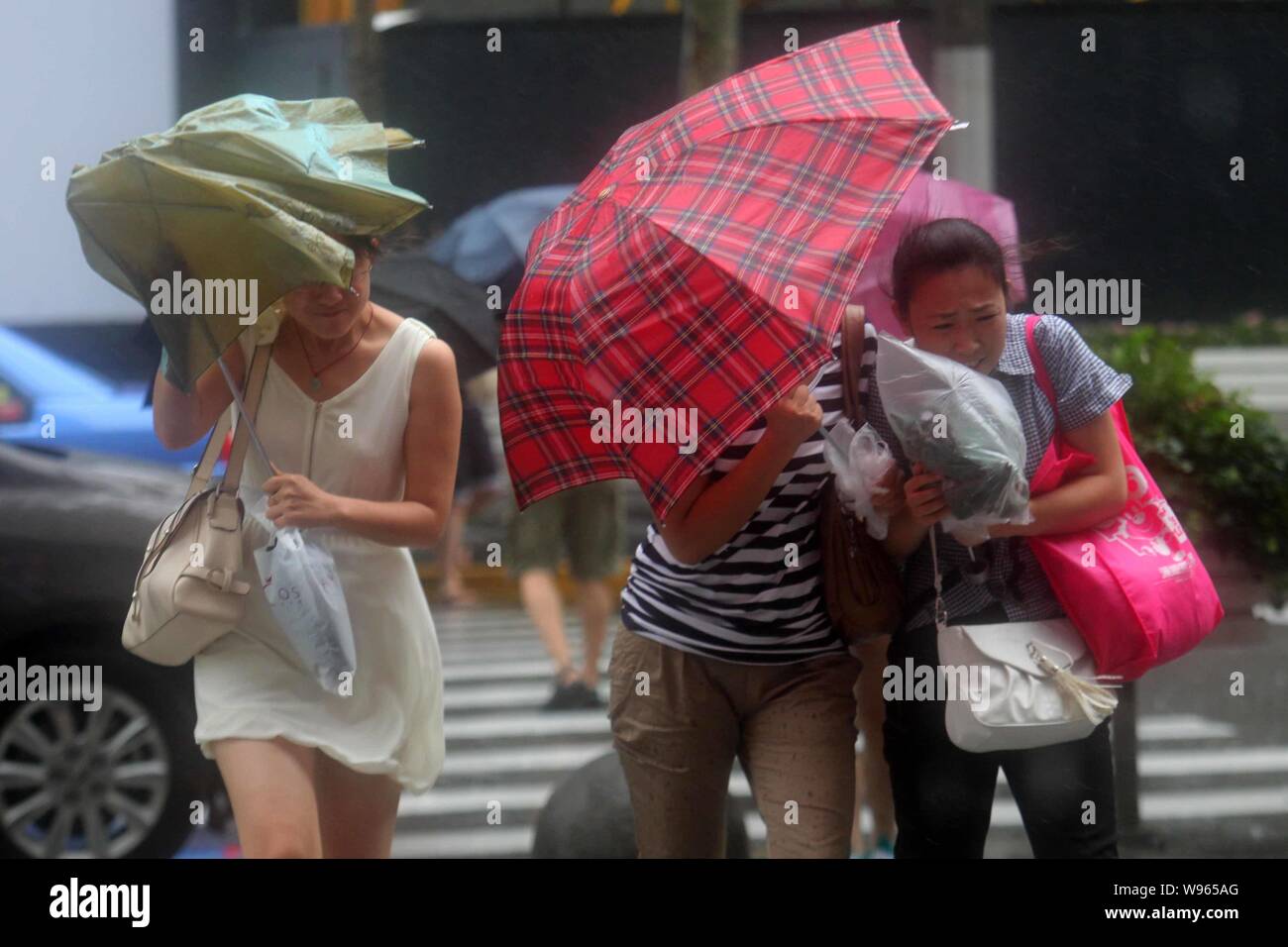 Pedestrians brave strong wind and heavy rain caused by Typhoon Haikui ...