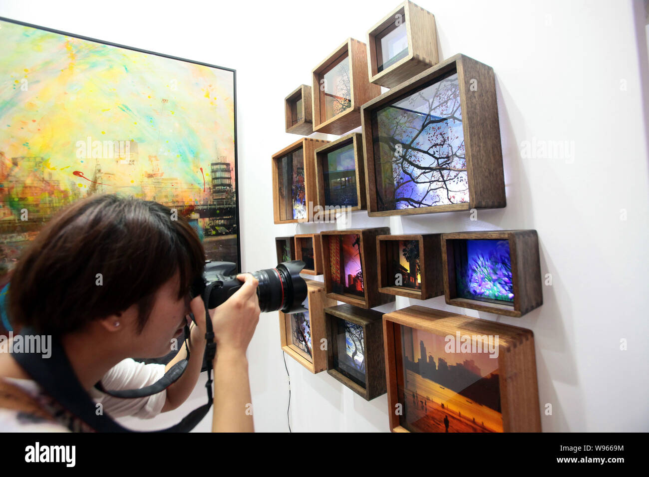 A visitor takes photos of an artwork during the SH Contemporary art ...