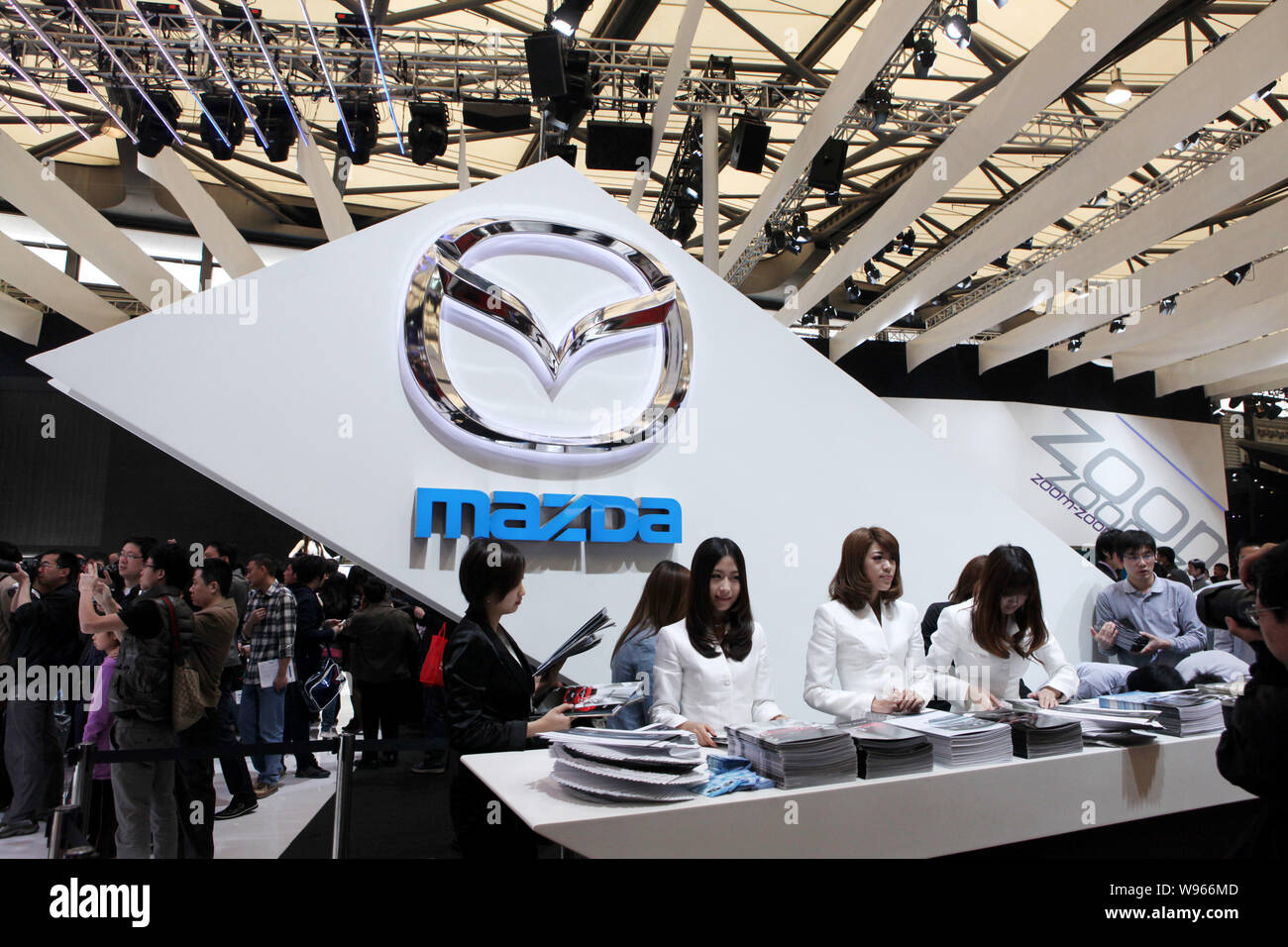 --FILE--Chinese employees prepare pamphlets at the stand of Mazda at ...