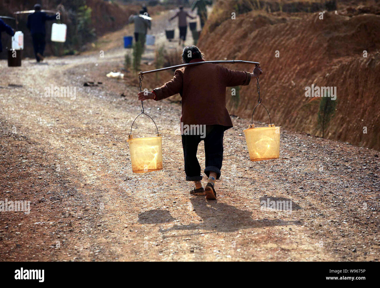 Chinese villagers shoulder buckets of water on their way back home from ...