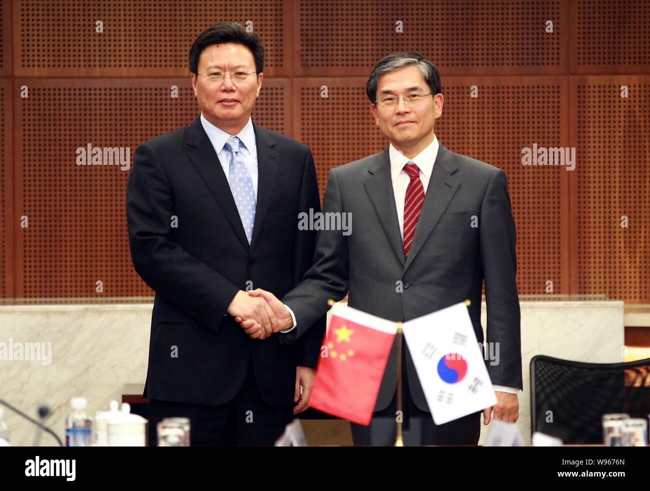 Yu Jianhua, Assistant Minister of Commerce of China, shakes hands with ...