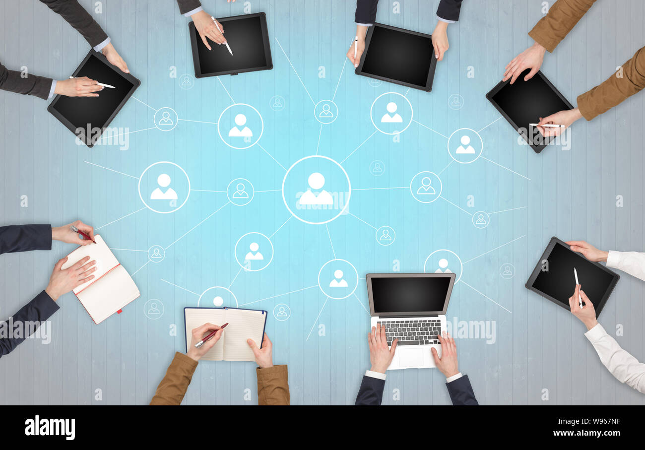 Group of people with devices in hands working in team on tablets ...