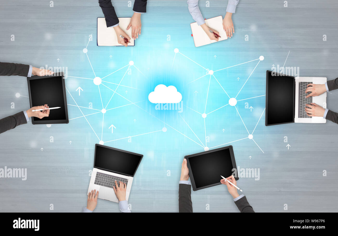 Group of people with devices in hands working in team on tablets ...