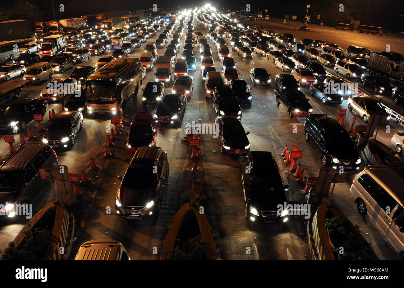 Masses of vehicles line up in long queues to pass through a toll ...