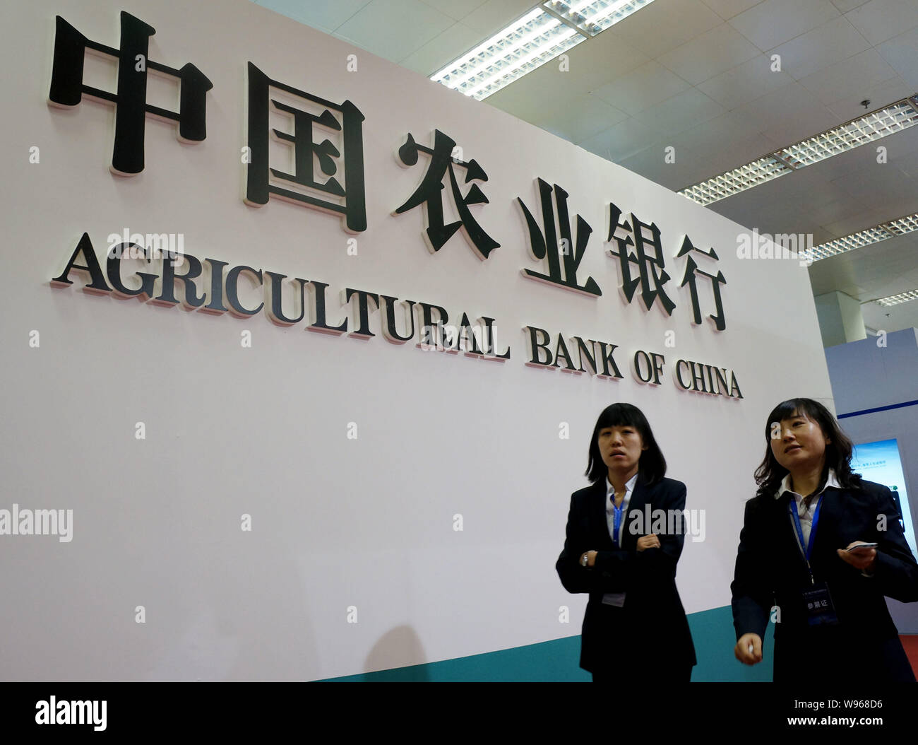 --FILE--Chinese employees walk past the stand of ABC (Agricultural Bank ...