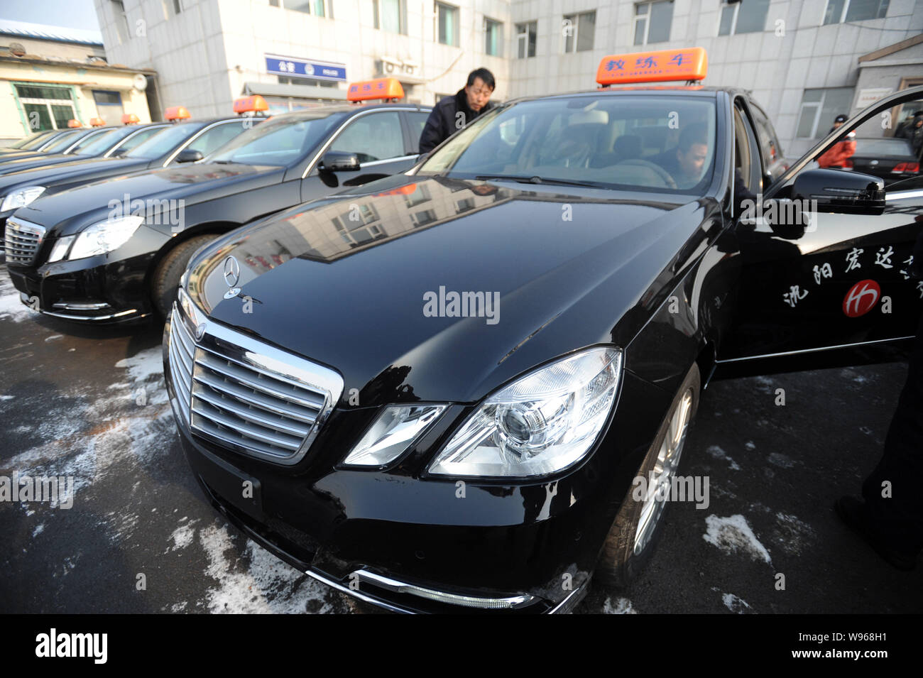 A Chinese driving student gets in a training vehicle of Mercedes-Benz ...