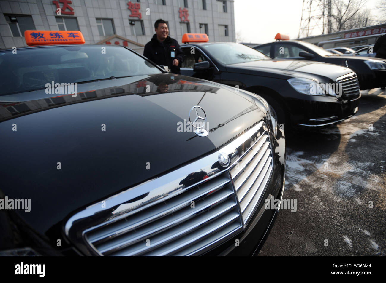 A Chinese journalist reports in front of a row of training vehicles of ...