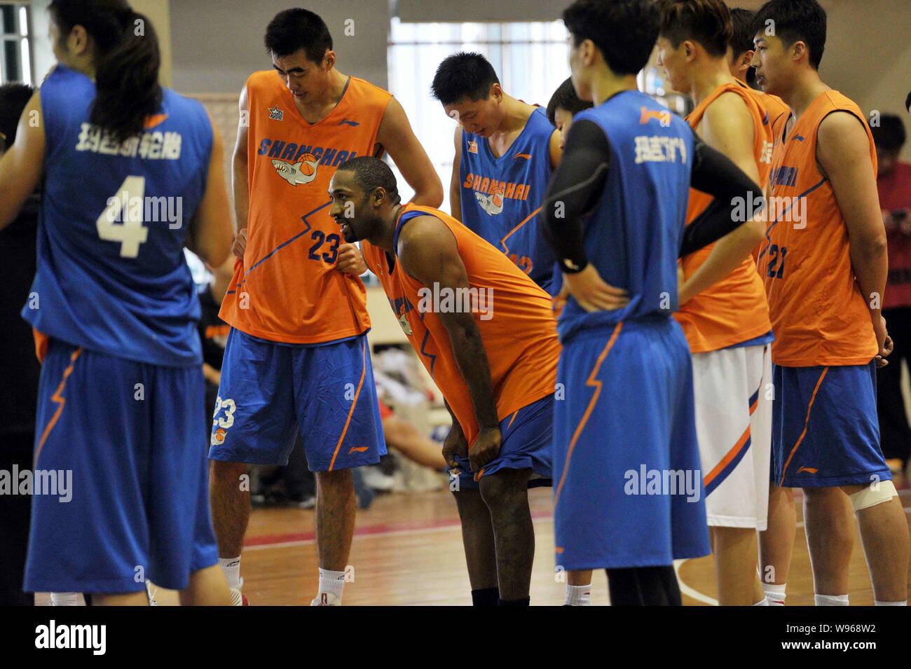 Gilbert Arenas of the Shanghai Sharks, center, rests amongst his ...