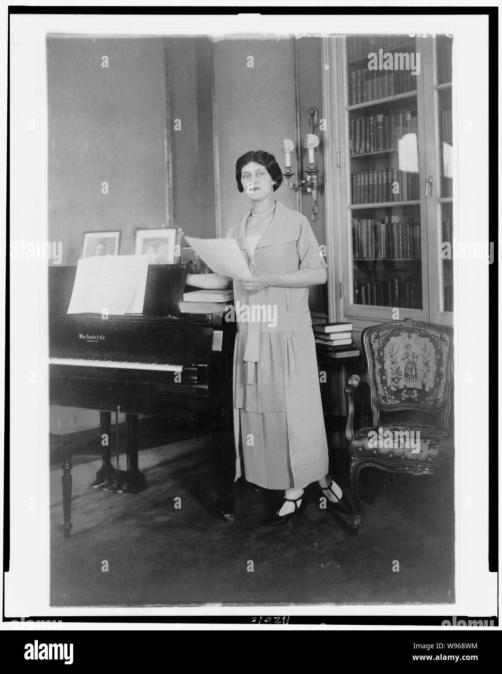 Alma Gluck, full-length portrait, standing by piano, facing slightly ...