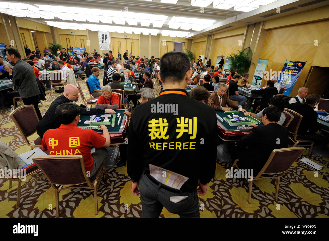 A referee watches participants competing during the 3rd World Mahjong ...