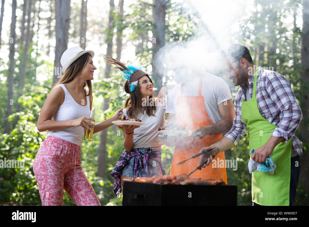 Happy friends enjoying barbecue and grill party outdoor Stock Photo - Alamy