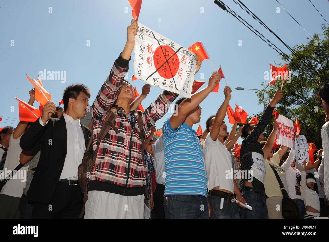 Chinese protestors wave Chinese national flags, hold up banners and ...