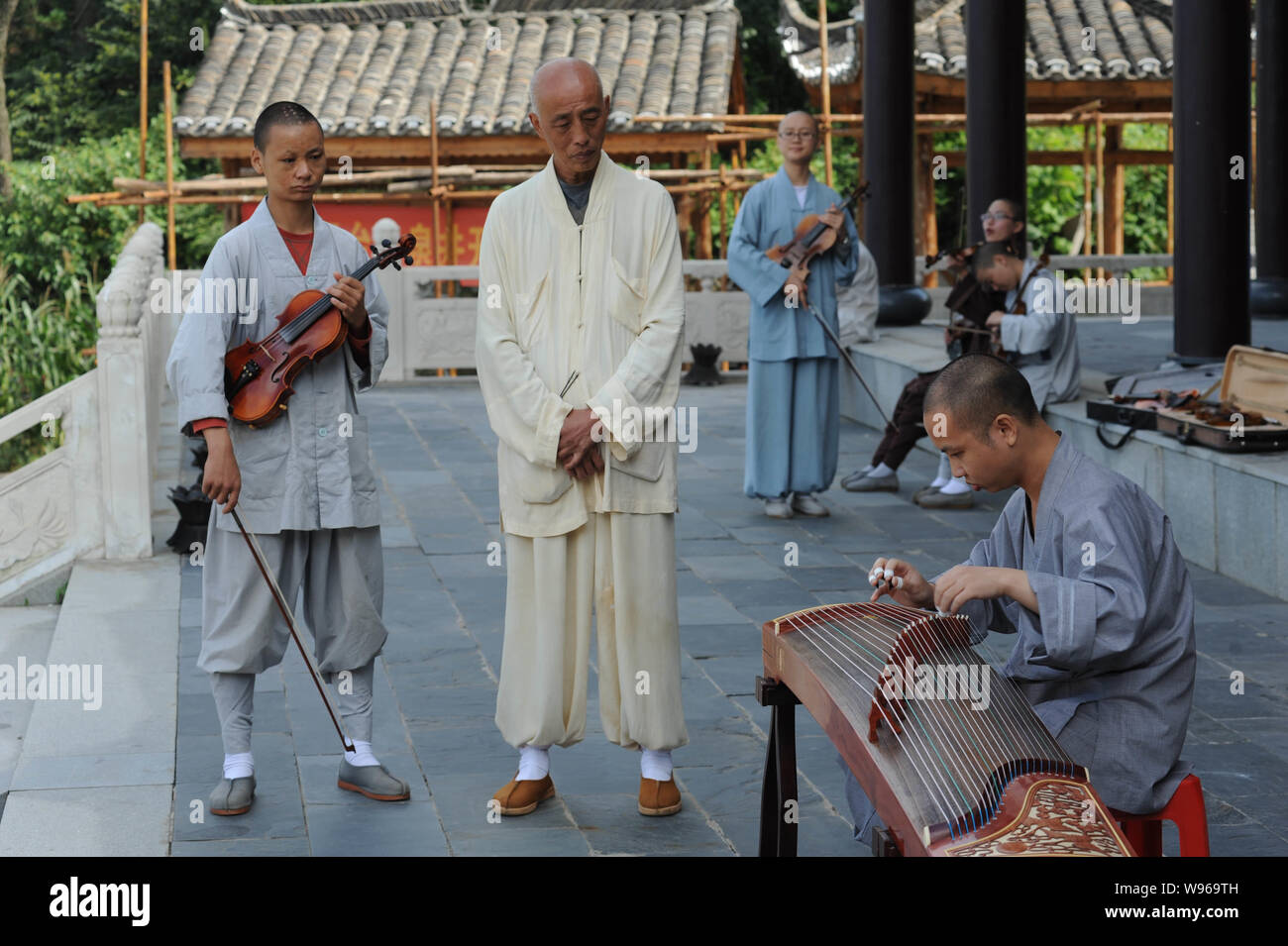 Chinese Buddhist monks and nuns of Guangxuan Art Troupe practice playing musical instruments ...