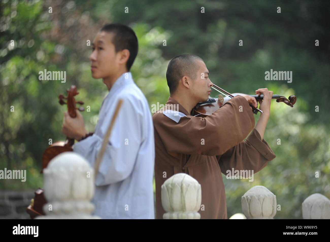A Chinese Buddhist monk and a nun of Guangxuan Art Troupe practice ...
