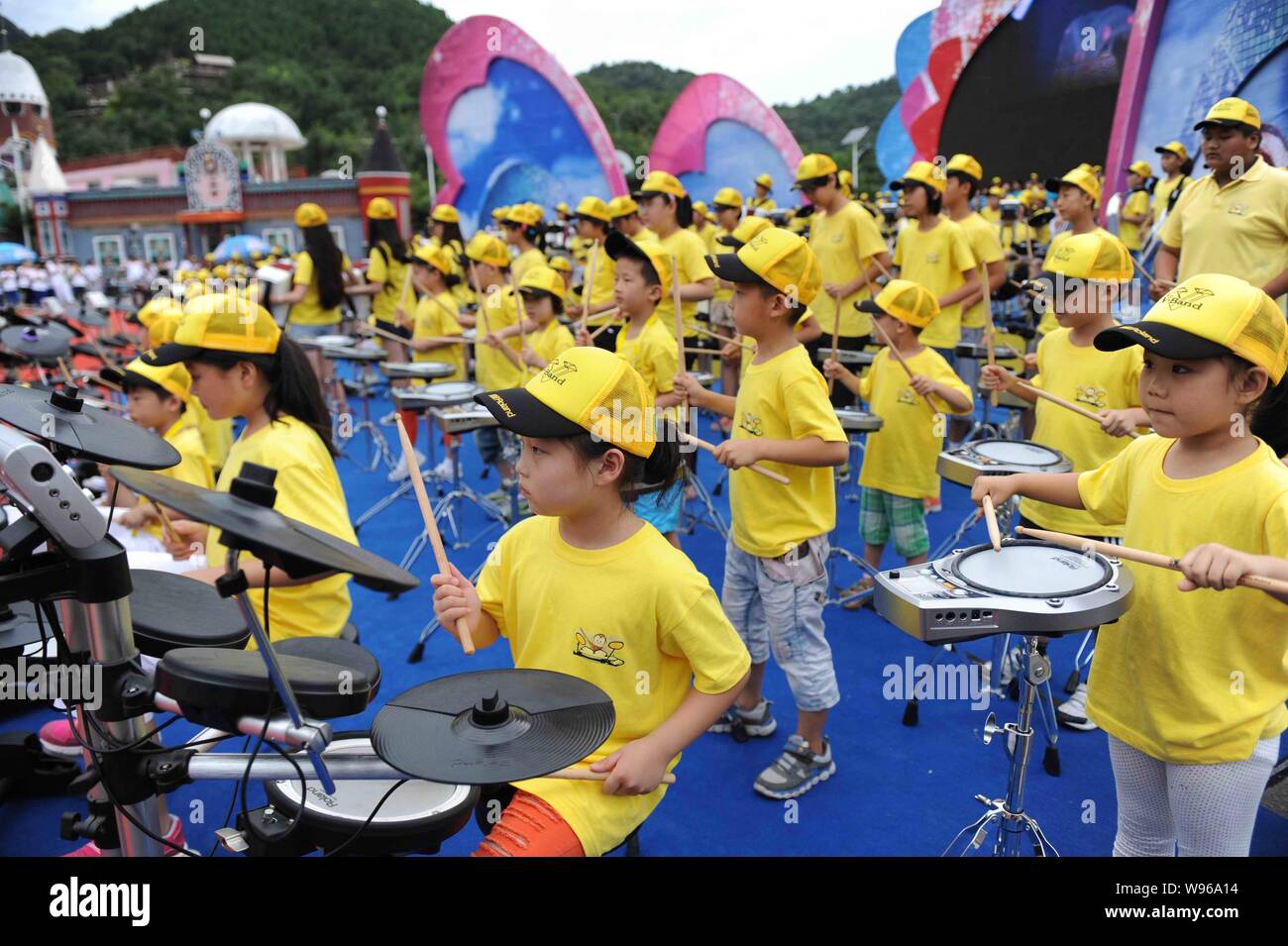 Young kids play electronic musical instruments during a performance to ...
