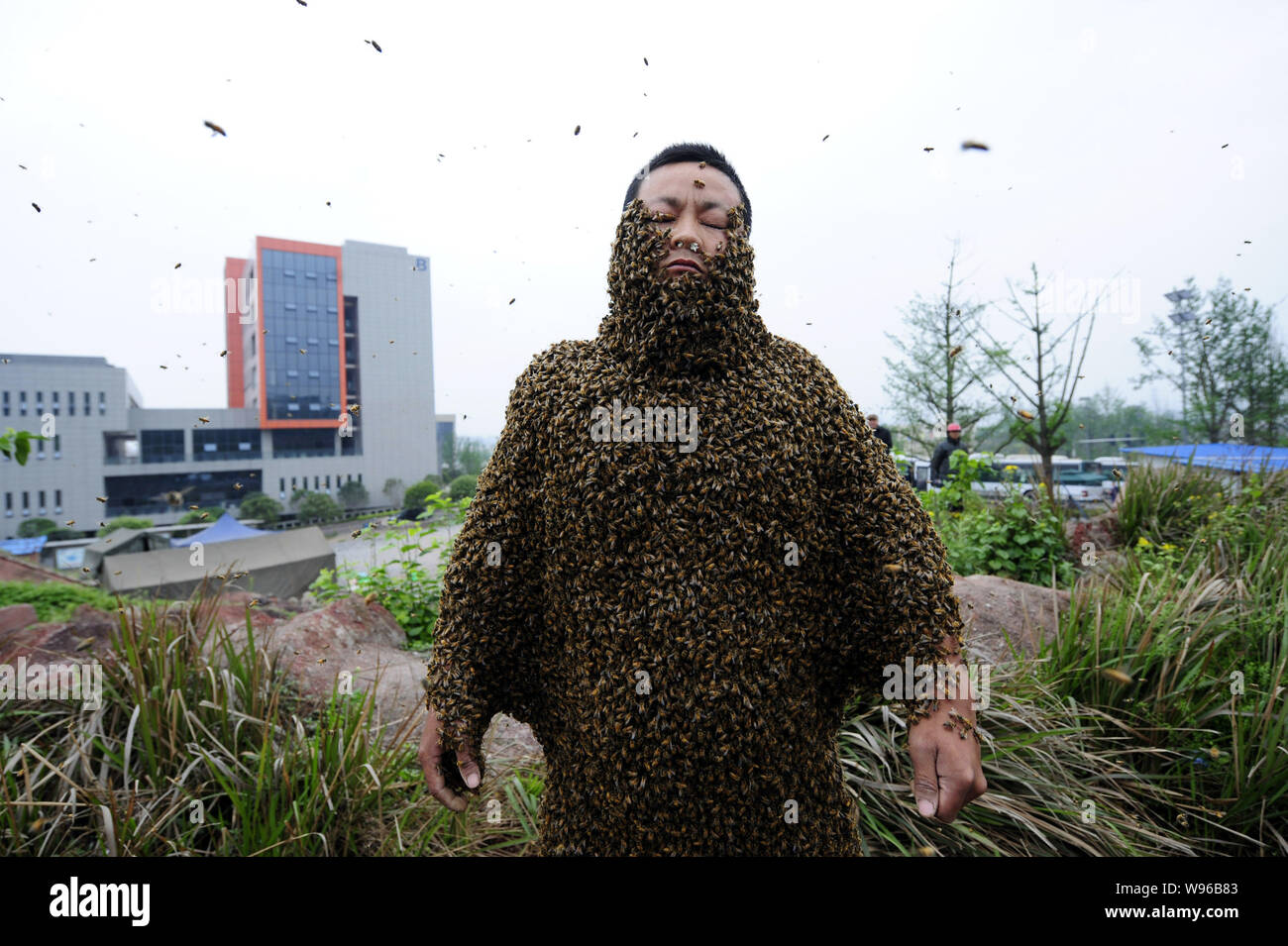 Chinese beekeeper She Ping whose body is covered by bees poses during a ...