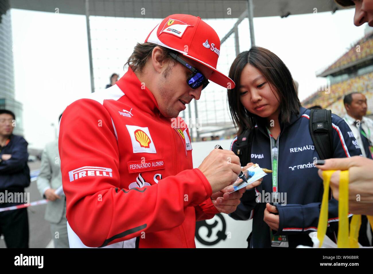 Spanish F1 driver Fernando Alonso of the Ferrari team signs for fans ...