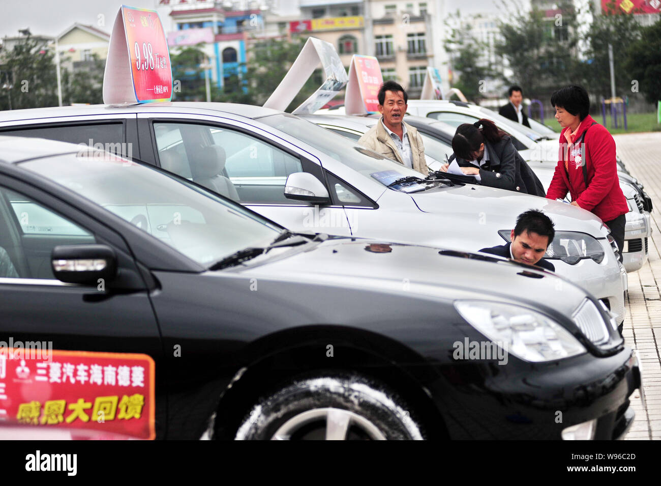 --FILE--Chinese visitors look at cars during an auto show in Qionghai ...