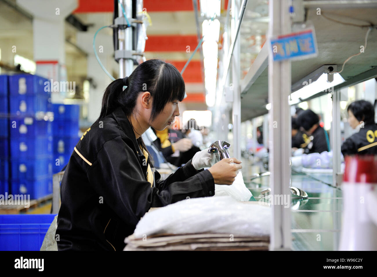 --FILE--Chinese workers check showerheads at a factory of Huihuang ...