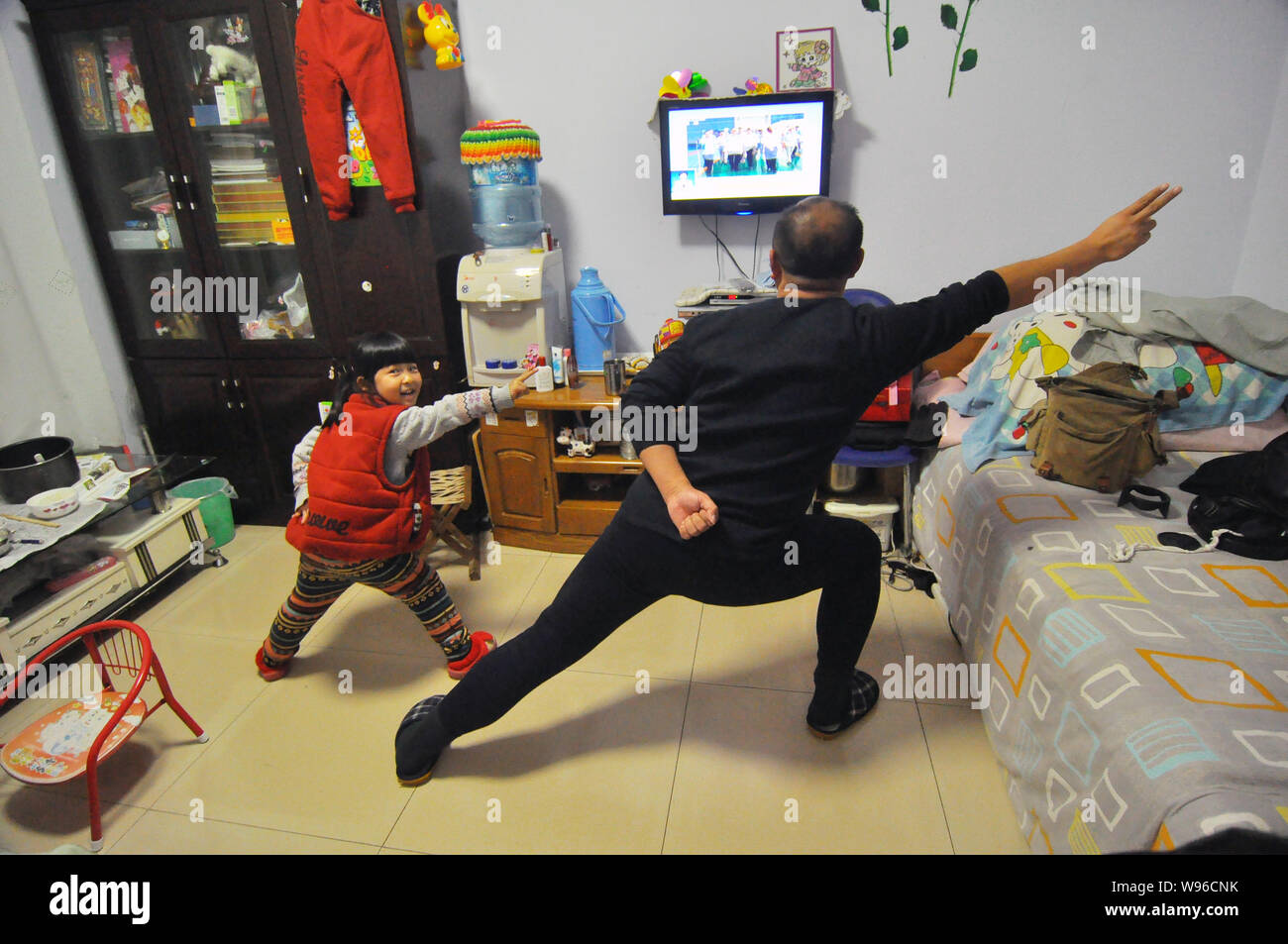 A Chinese man and his young daughter mimic the hand signals of flight ...