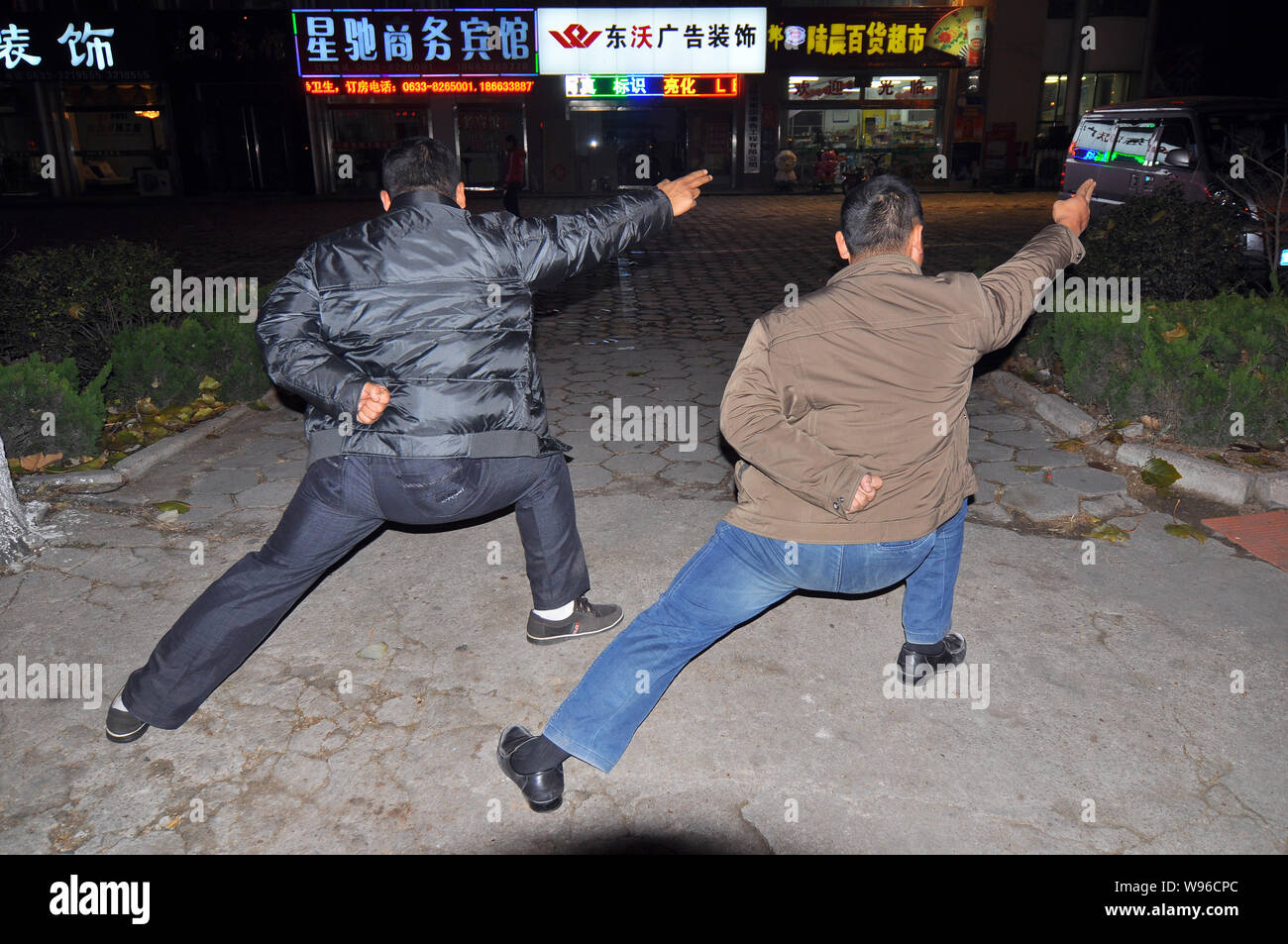 Two Chinese men mimic the hand signals of flight deck crew directing J ...