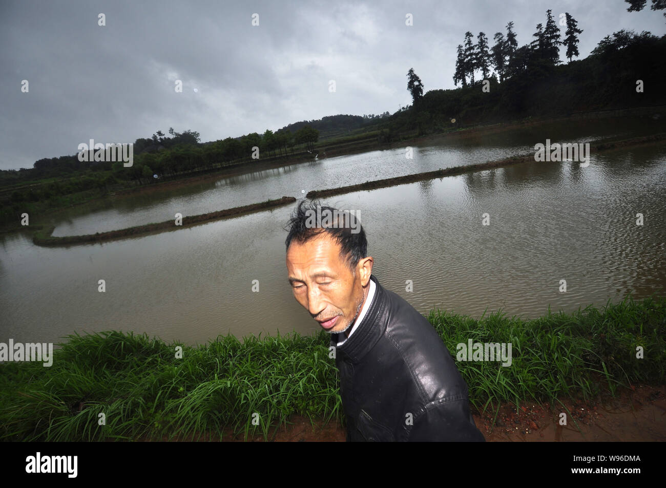 A Chinese farmer walks past his farms submerged by floods caused by ...