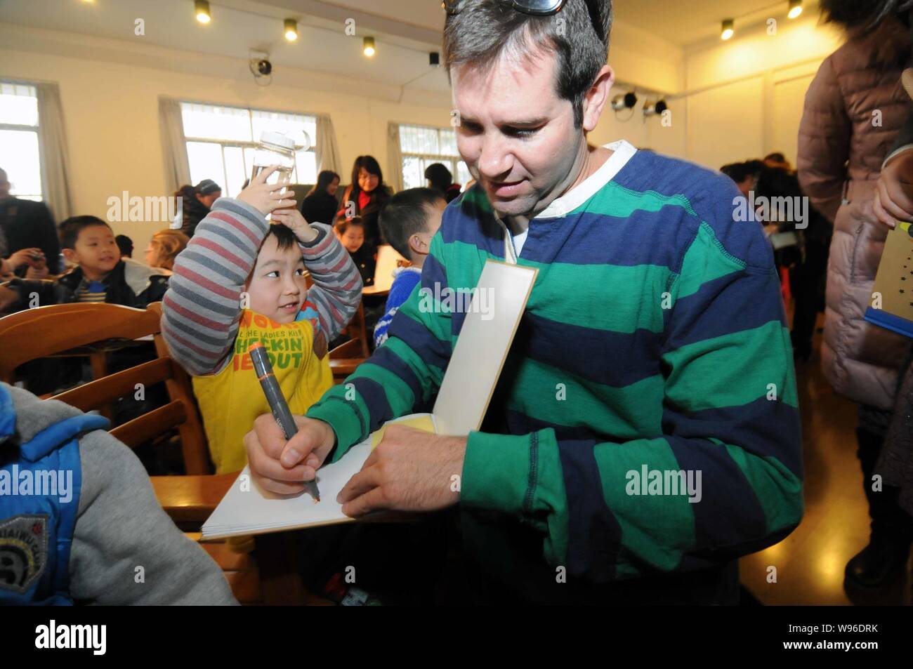Israeli childrens book writer Elad Weingrod signs his name on the book ...