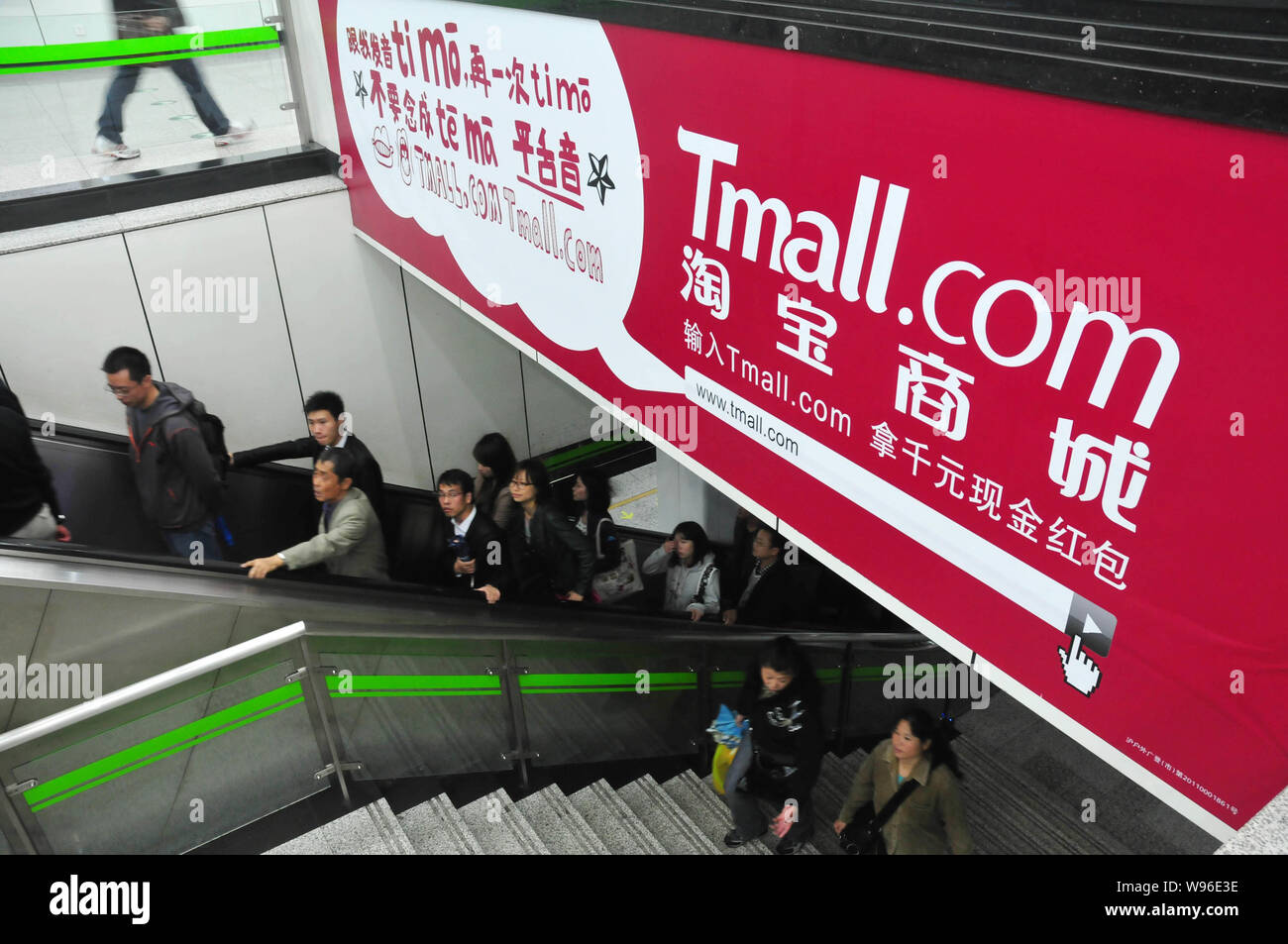 --FILE--Passengers pass by an advertisement for online shopping site Tmall.com (Taobao Mall) at ...