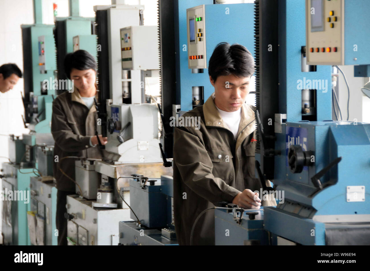 Chinese factory workers operate machines at the plant of Nanyang Senba ...